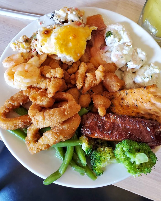 A seafood buffet plate that would make Neptune himself nod in approval—fried seafood, prime rib, and vegetables creating the perfect surf-and-turf harmony.