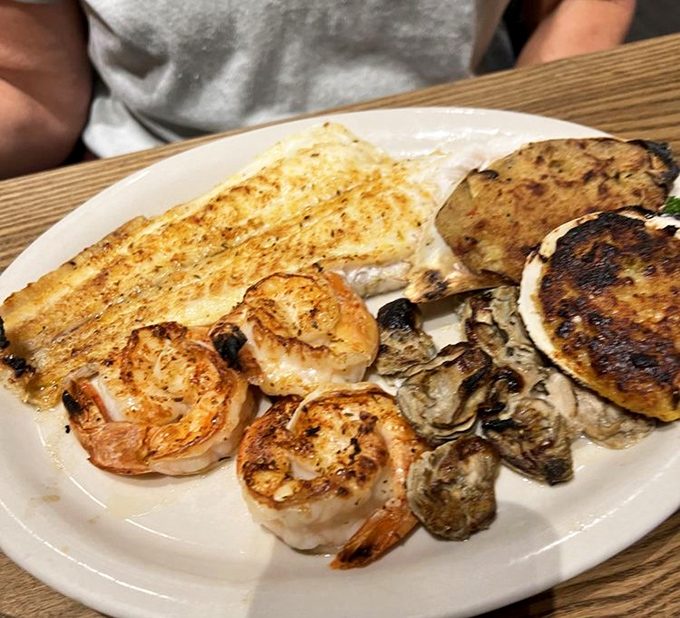 This seafood medley features perfectly grilled treasures from the deep. The char marks tell stories of flame-kissed perfection.