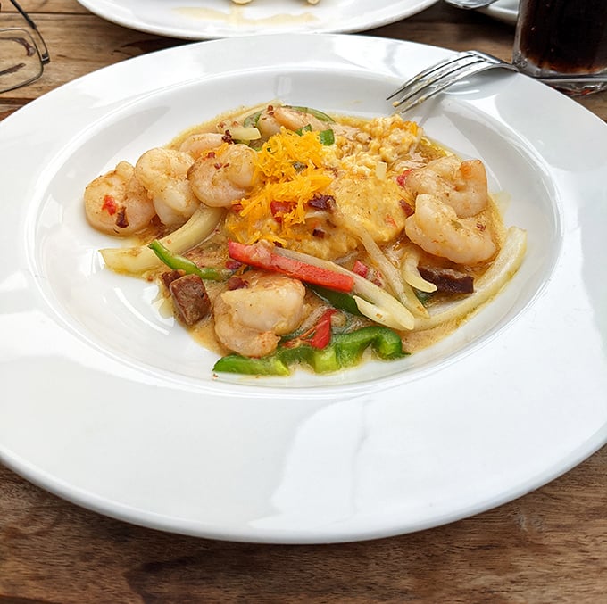 Plump shrimp lounging on creamy grits with colorful vegetables—like a seafood vacation happening right on your plate.