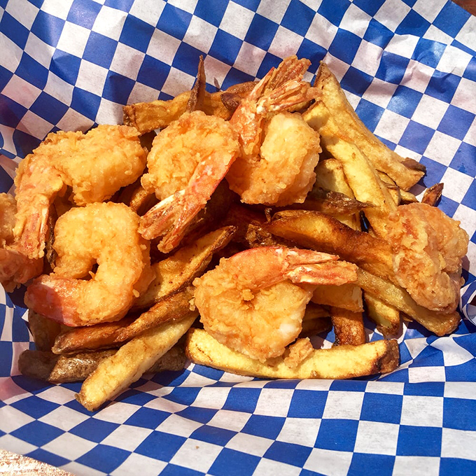 Plump, golden shrimp nestled among crispy fries—a seafood treasure chest that makes you wonder why you'd ever order anything else.
