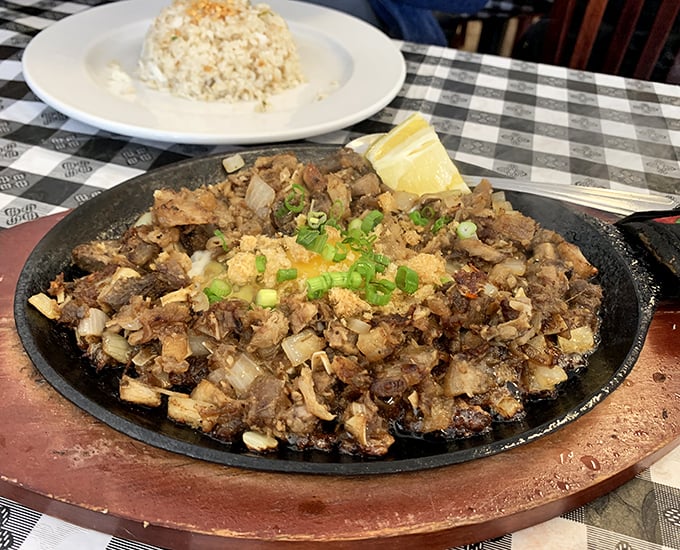 Sizzling sisig—where chopped pork parts meet a hot skillet and create the kind of symphony that would make Mozart put down his fork and applaud.
