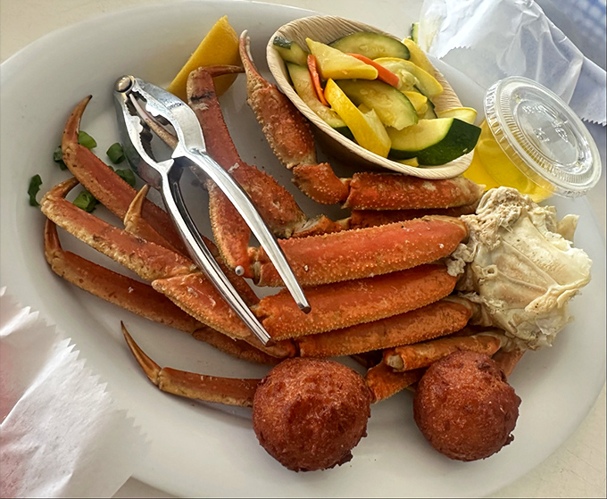 Snow crab legs arranged like nature's puzzle—where cracking the code rewards you with sweet, tender meat. Those hush puppies aren't just sidekicks.