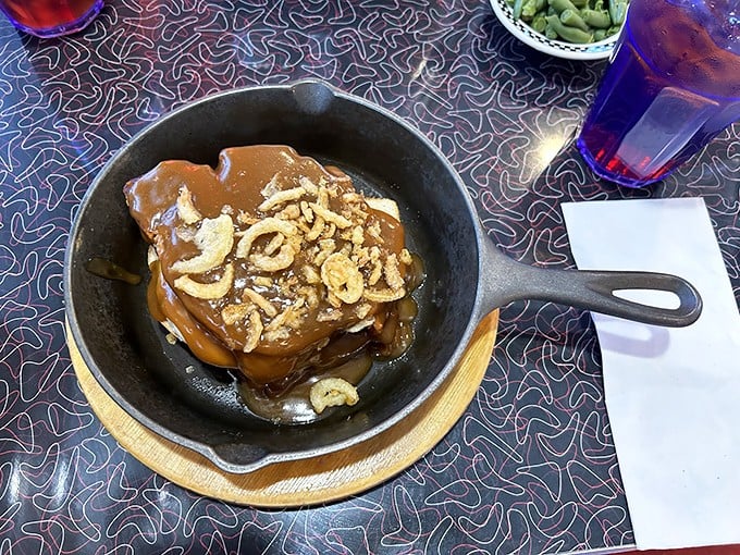 Sizzling stack meatloaf in a cast iron skillet topped with crispy onions and gravy—this isn't your Monday night leftovers, it's a Midwest masterpiece.