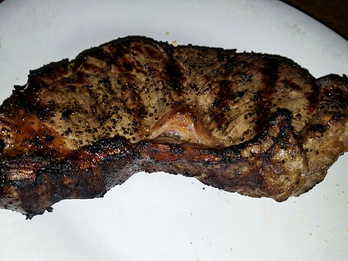 Behold the star of the show – a steak with the kind of char that whispers tales of a well-seasoned grill and decades of cooking wisdom.