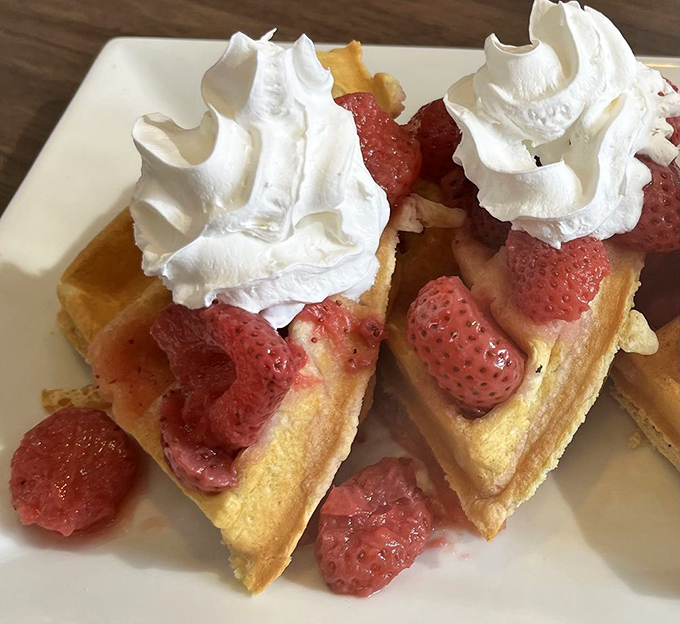 Golden waffles playing host to fresh strawberries and whipped cream – breakfast's way of saying, "Who needs adulting today?"