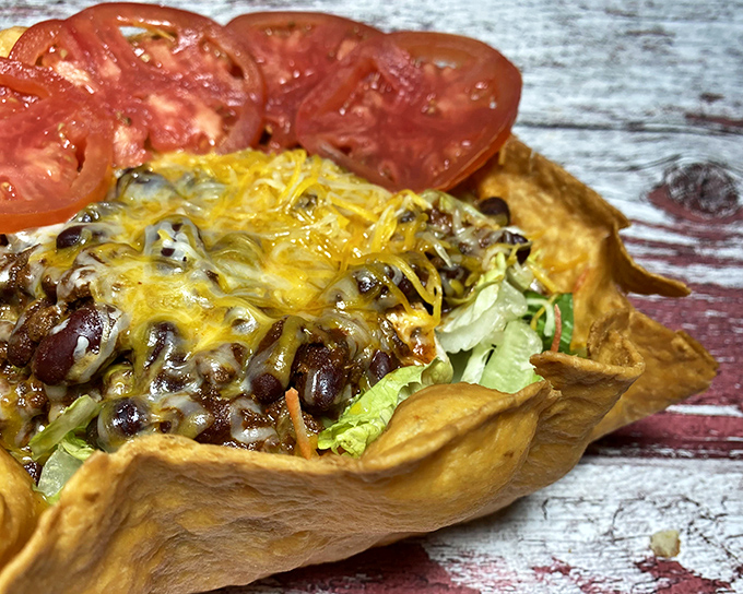 Taco salad that breaks free from its tortilla prison—a rebellious feast of beans, cheese, and lettuce that refuses to be contained by conventional boundaries.