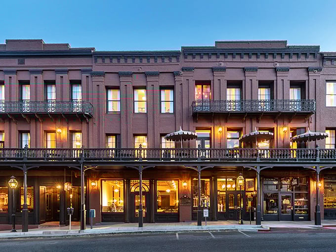 The National Exchange Hotel glows at dusk, its windows illuminated like a Victorian-era Instagram grid of hospitality and history.