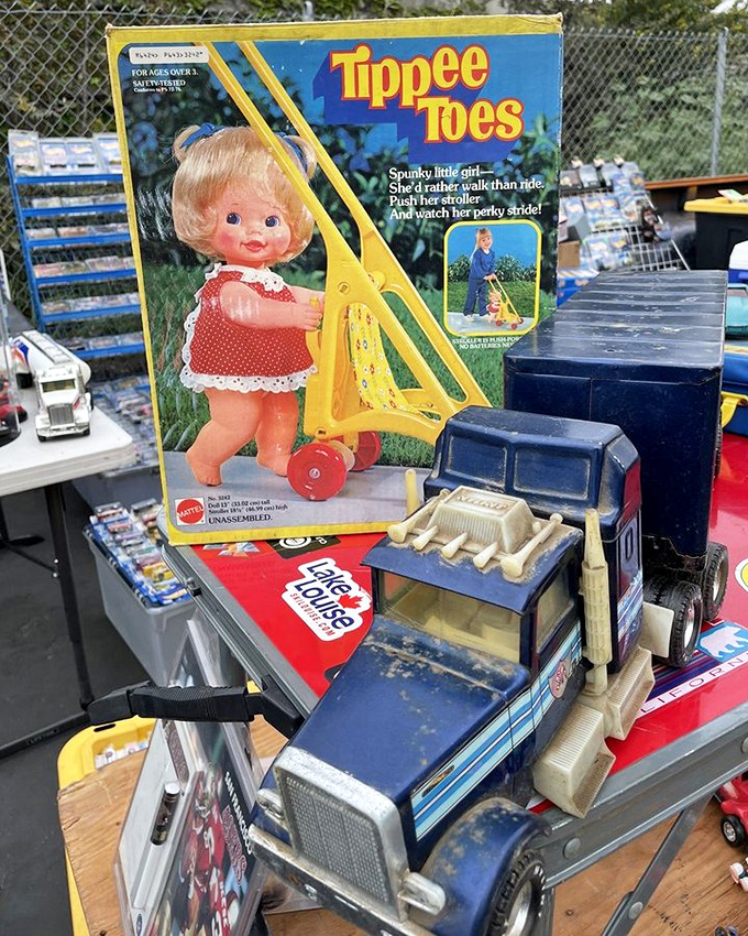 Vintage Tippee Toes doll box shares space with classic toy trucks. These relics of childhoods past remind us that playtime was simpler but no less magical.