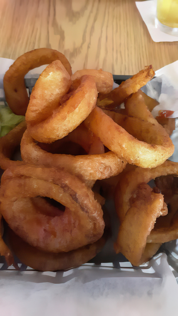 Onion rings that shatter with satisfying crispness, revealing sweet onion centers—the kind that make you forget your table manners as you reach for another.