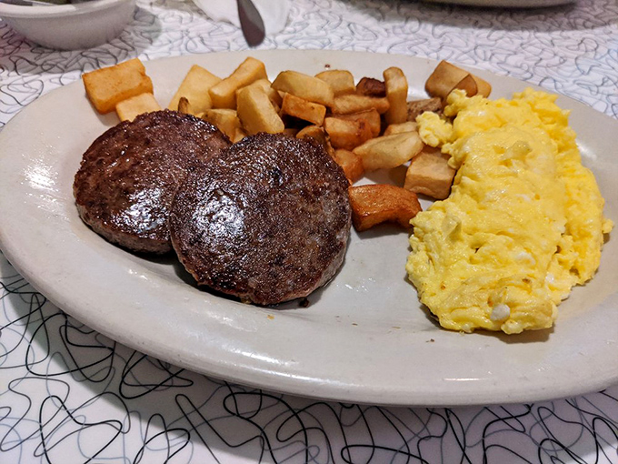 Breakfast doesn't get more serious than this—two sausage patties, golden home fries, and fluffy scrambled eggs that would make your grandmother proud.