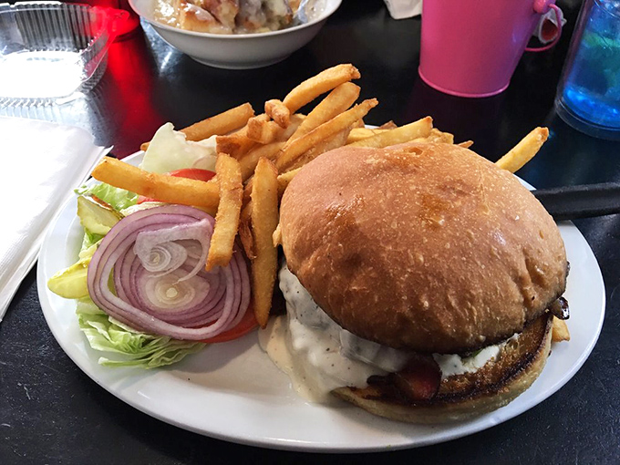 This isn't just a burger – it's a towering monument to the art of lunch, complete with a supporting cast of golden fries worthy of their own standing ovation.