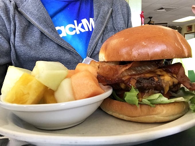 The burger that silences conversation. Notice the fresh fruit side—that's called balance, my friends, that's called sophistication.