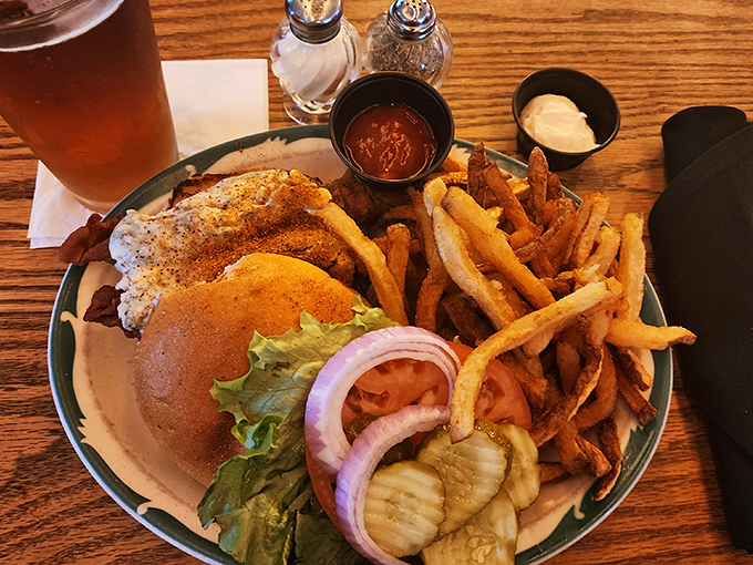 A burger that demands two hands and your full attention, complete with golden fries and house-made pickles that would make your grandmother proud.