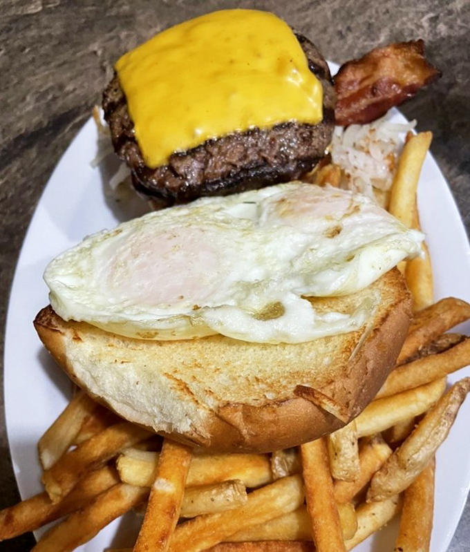 Breakfast of champions: a burger topped with melty cheese, a sunny-side-up egg, and enough fries to share (but you won't want to).