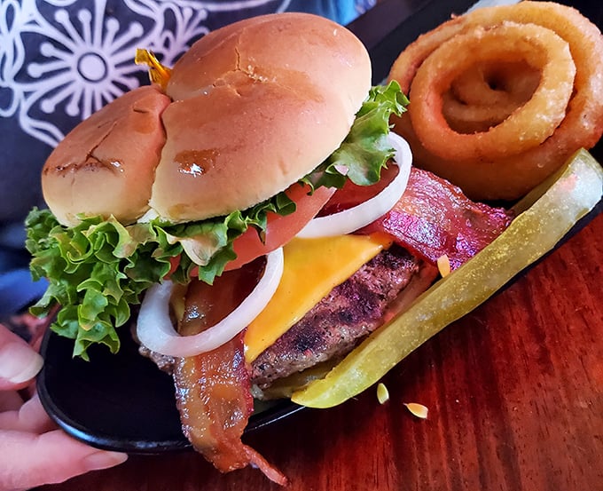 A burger that doesn't need fancy aioli or artisanal buns to impress—just perfect beef-to-bun ratio, fresh toppings, and those golden onion rings standing guard.