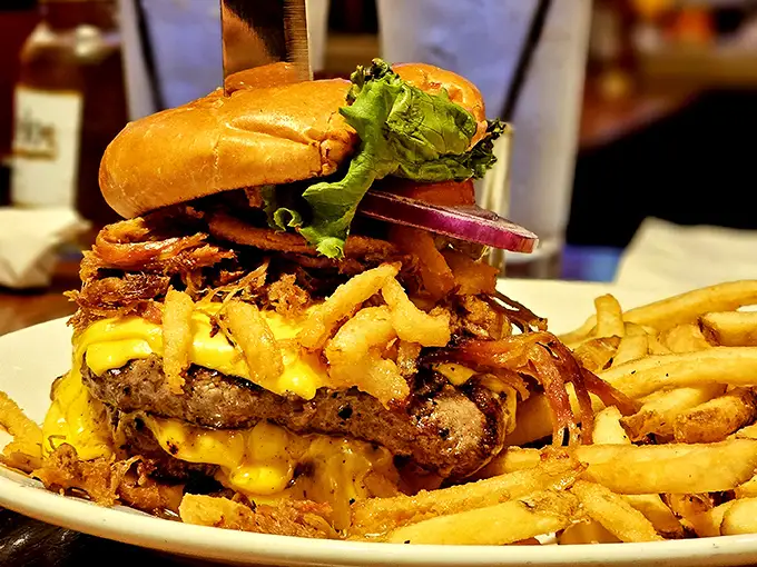 Not just a burger—a towering monument to excess that requires both hands, several napkins, and absolutely zero regrets.