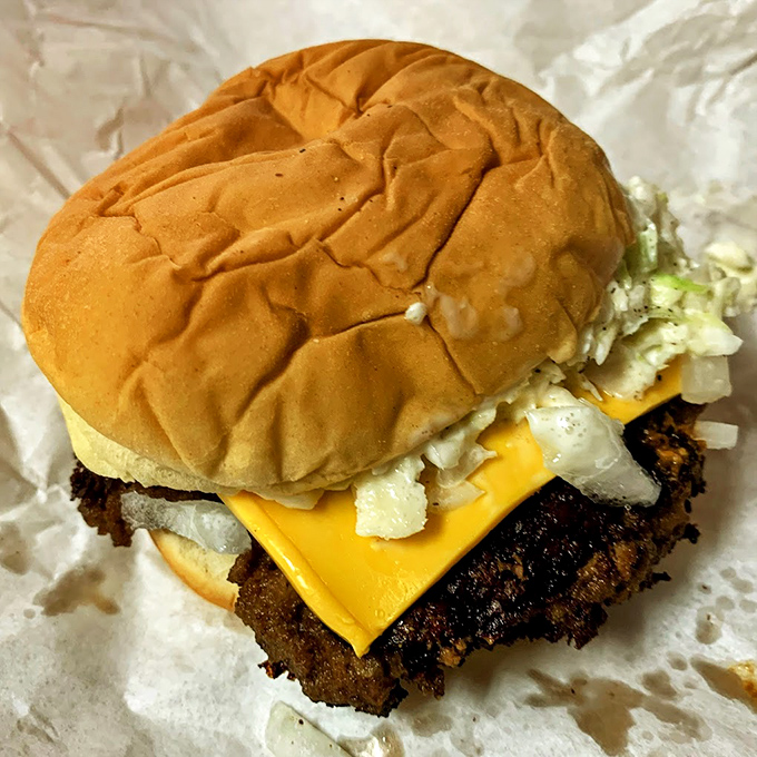 Crispy-edged patty, melty American cheese, and a perfectly toasted bun – the holy trinity of cheeseburger perfection in its natural habitat.
