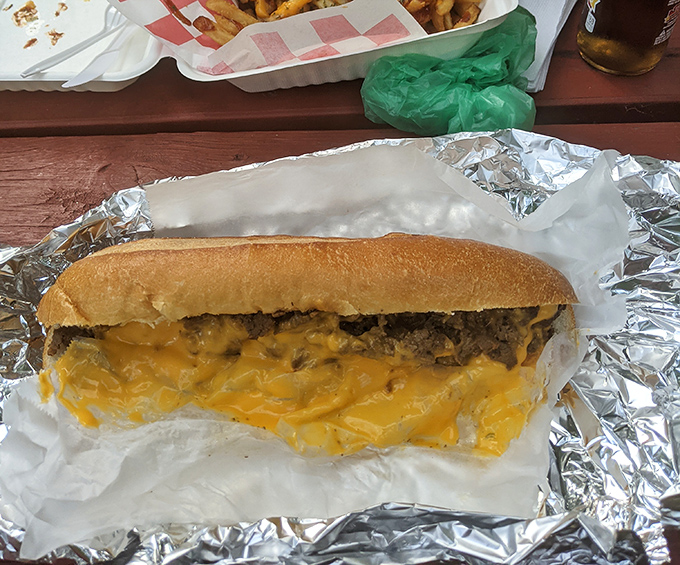 Yellow cheese cascading over seasoned beef like Niagara Falls, if the falls were made of deliciousness. This cheesesteak doesn't just satisfy hunger—it conquers it.
