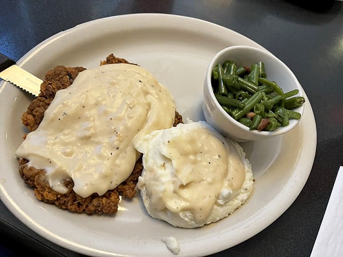 Country fried steak smothered in peppery white gravy alongside green beans that actually taste like vegetables, not just salt. Grandma would approve. 