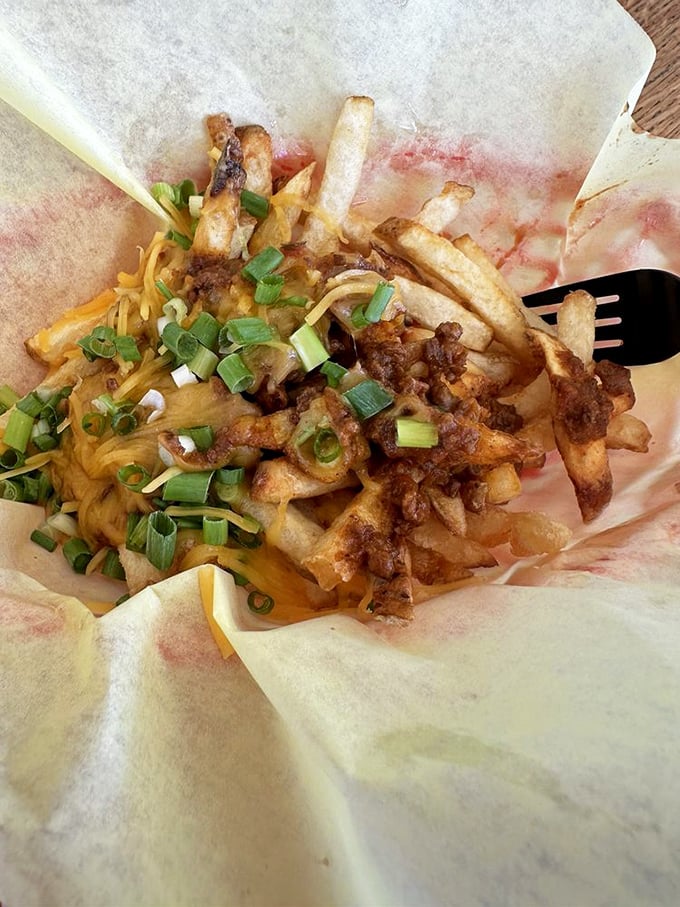 These loaded fries aren't just wearing cheese and chili—they're flaunting them like vintage designer labels. Fork required, napkins essential, regrets impossible.