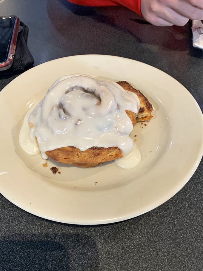 This isn't just a cinnamon roll—it's a spiral-shaped love letter to your taste buds, wearing its cream cheese frosting like a decadent winter coat.