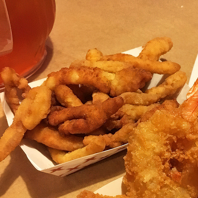 Clam strips nestled in their paper-lined basket—crispy, tender morsels that disappear faster than your resolution to eat light today.