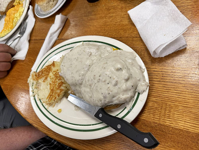 Country gravy blankets this biscuit like a warm Southern hug. Comfort food architecture at its finest—sturdy foundation, generous middle, satisfying finish.