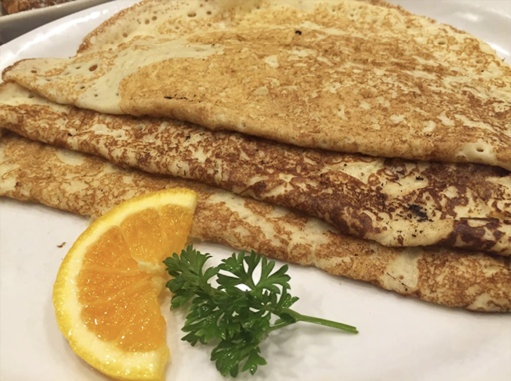 Golden-brown pancakes that look like they've been kissed by Nordic sunshine, with a citrus garnish that adds just the right amount of morning brightness.
