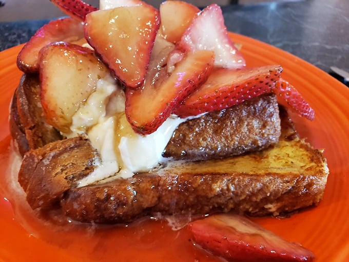 French toast that's living its best life, crowned with fresh strawberries and cream—carbs have never looked so worthy of worship.