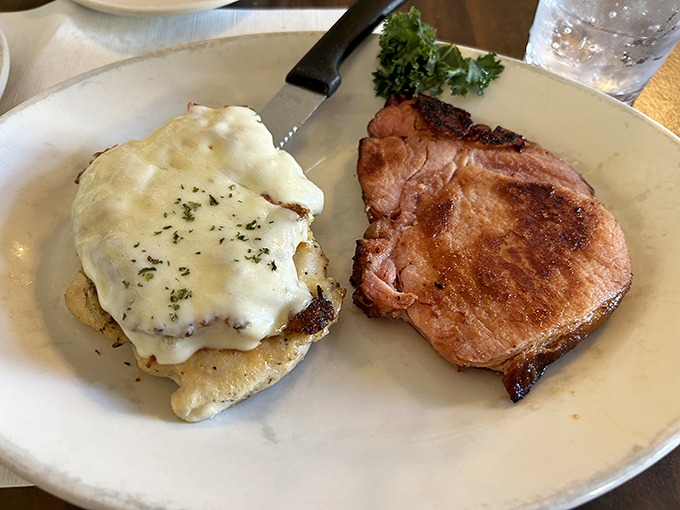 A perfect marriage on a plate: juicy pork chop meets chicken smothered in melted cheese – proof that sometimes the simplest combinations yield the greatest pleasure.