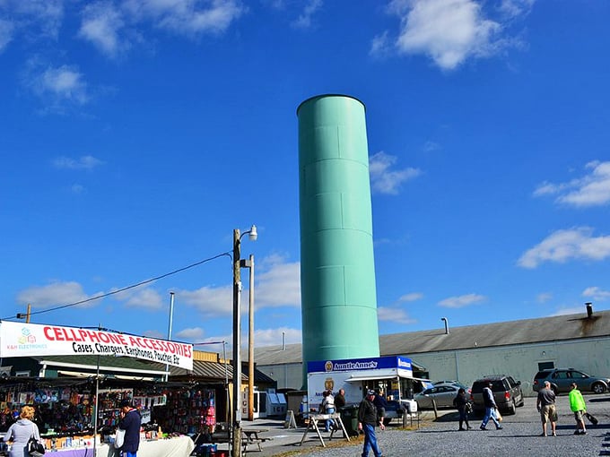 The iconic teal silo stands sentinel over the market grounds, while vendors hawk everything from phone cases to fresh produce beneath its watchful gaze.