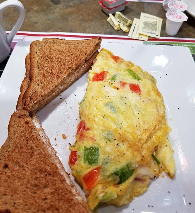 An omelet bursting with vegetables like a garden party decided to throw itself onto your breakfast plate – pure morning joy.
