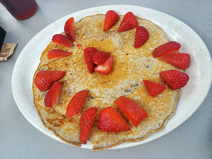 Pancake artistry that turns breakfast into a special occasion. Those strawberries aren't just toppings, they're jewelry for your meal.