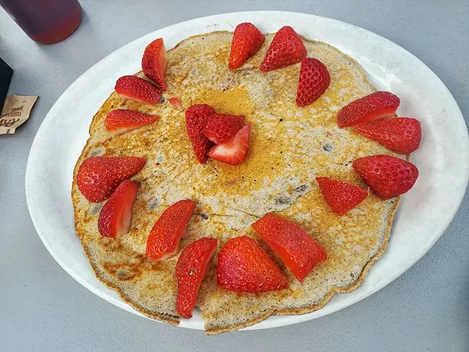 Pancake artistry that turns breakfast into a special occasion. Those strawberries aren't just toppings, they're jewelry for your meal.