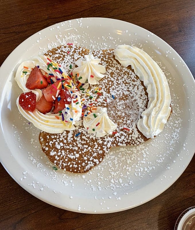 A pancake adorned with fresh strawberries and whipped cream—proof that sometimes the prettiest foods are also the most delicious.