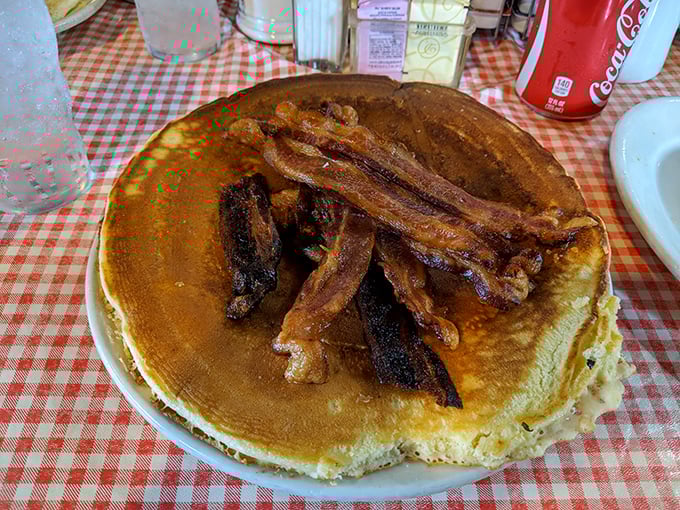 That's not just a pancake—it's a golden disk of joy topped with bacon that's achieved the perfect balance between crispy and chewy.