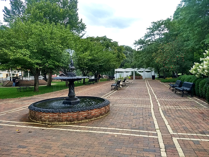 Town squares like this aren't just pretty—they're community living rooms where benches invite conversation and fountains provide the background music.
