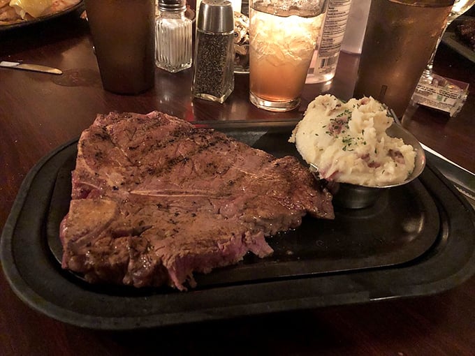 This T-bone doesn't just hang off the plate—it annexes neighboring territory with the confidence of meat that knows its own greatness.