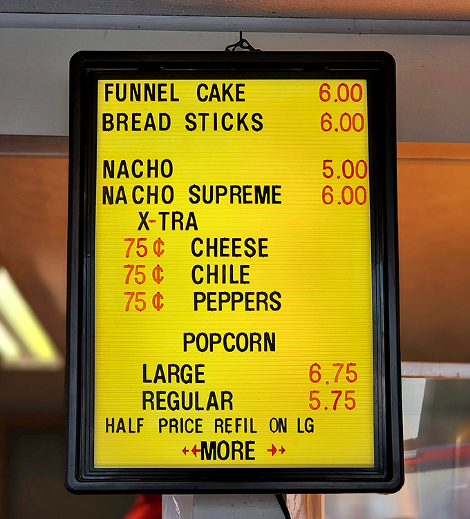 The menu board – a nostalgic yellow beacon offering funnel cakes and nachos supreme. Cinema cuisine that hasn't changed because it doesn't need to.