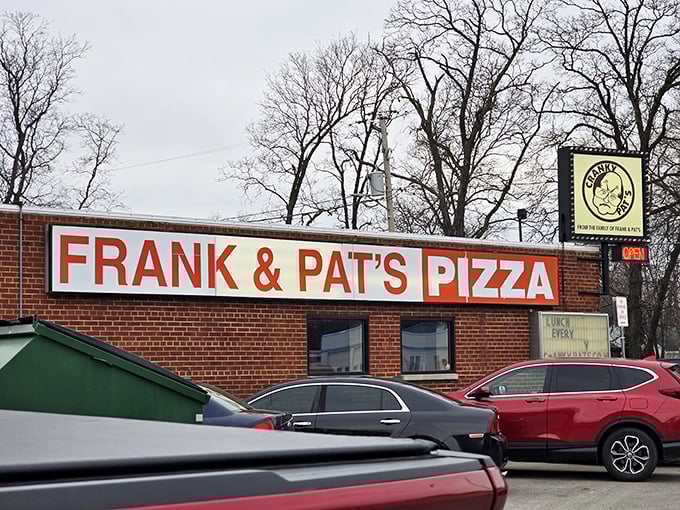 Cranky Pat's bold red sign cuts through winter snow like a promise – great pizza waits, regardless of Wisconsin weather!
