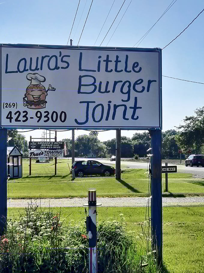 Laura's cheerful sign with that grinning burger mascot – when your food is this good, it practically smiles back at you.