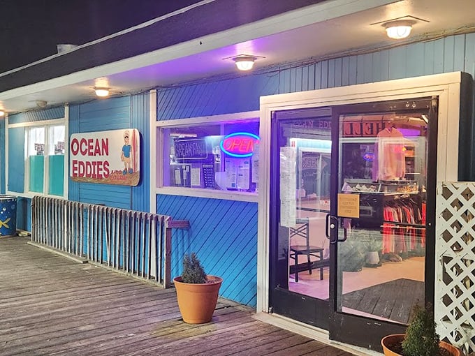 The blue-sided Ocean Eddie's glows with neon promise at dusk – a beacon for hungry beachgoers seeking seafood salvation.