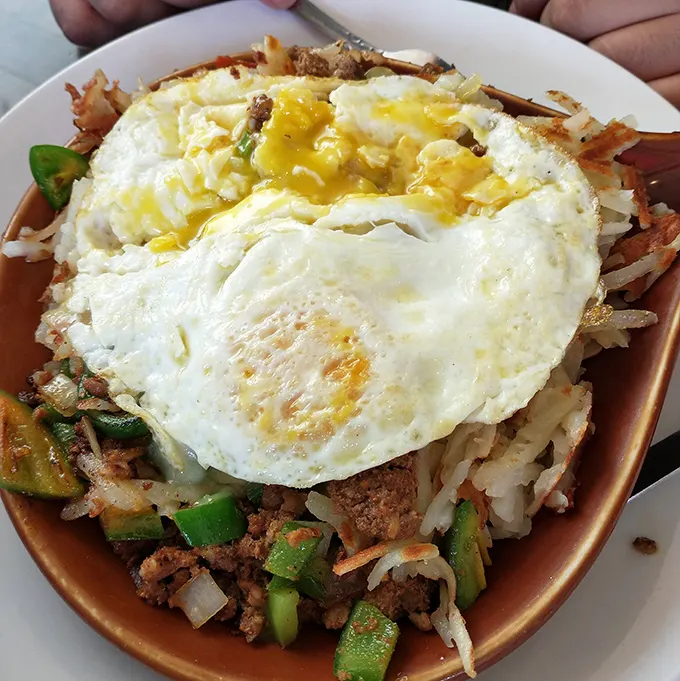 When breakfast can't decide what it wants to be, it becomes this glorious skillet—a mountain of ingredients with a perfectly fried egg summit.