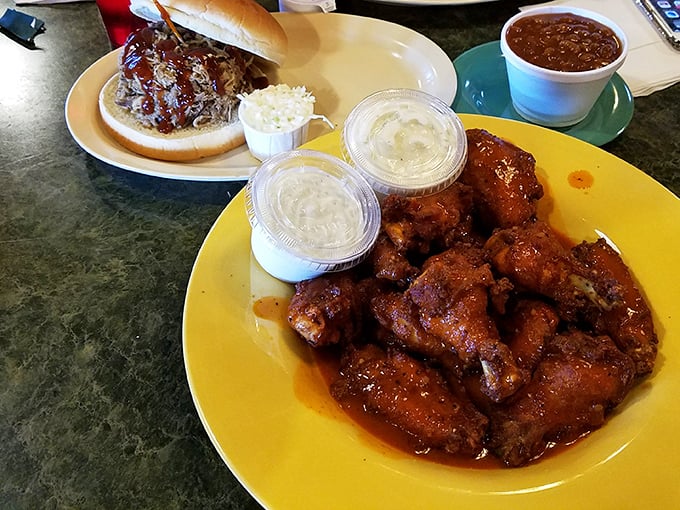 Wings and a sandwich sharing table space like old friends. That sauce isn't just coating the chicken—it's transforming it into something worth crossing state lines for.