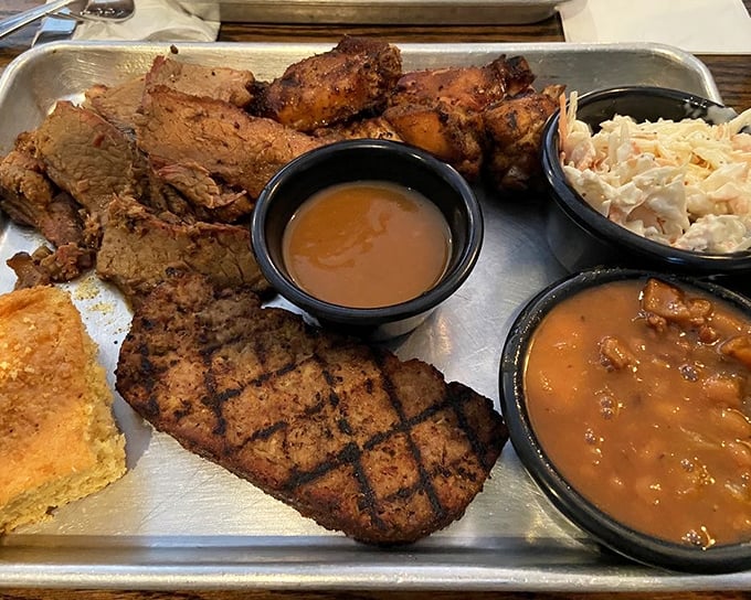 The BBQ sampler: where indecision becomes a virtue. That cornbread square isn't just a side—it's the perfect sauce-sopping companion.