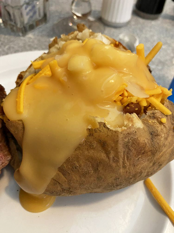 This loaded baked potato isn't just a side dish – it's practically wearing a cheese tuxedo to your mouth's formal dinner party.
