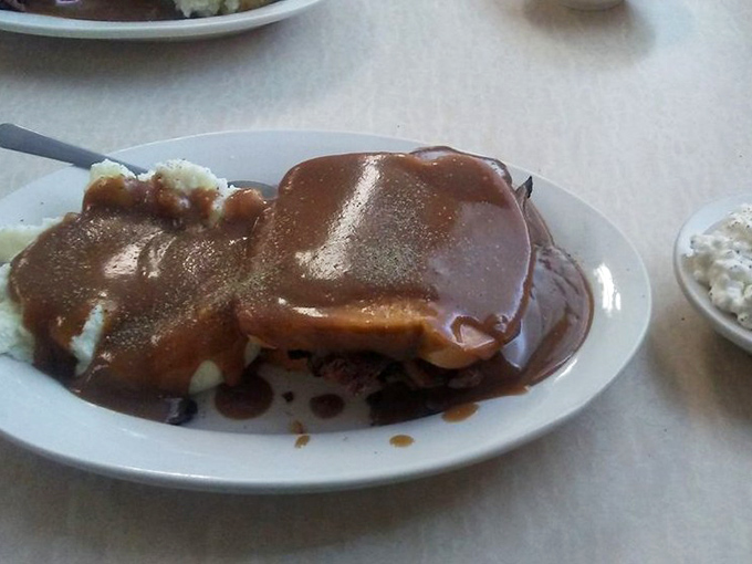 The hot beef sandwich—where gravy isn't just a topping but a warm, savory lake in which all your worries can dissolve.