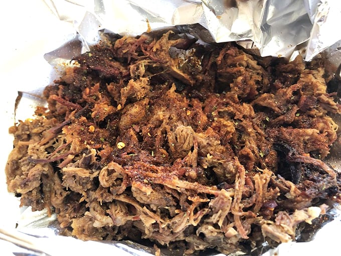 Behold the brisket—tender strands of beef with a beautiful bark that whispers sweet, smoky nothings to your taste buds.
