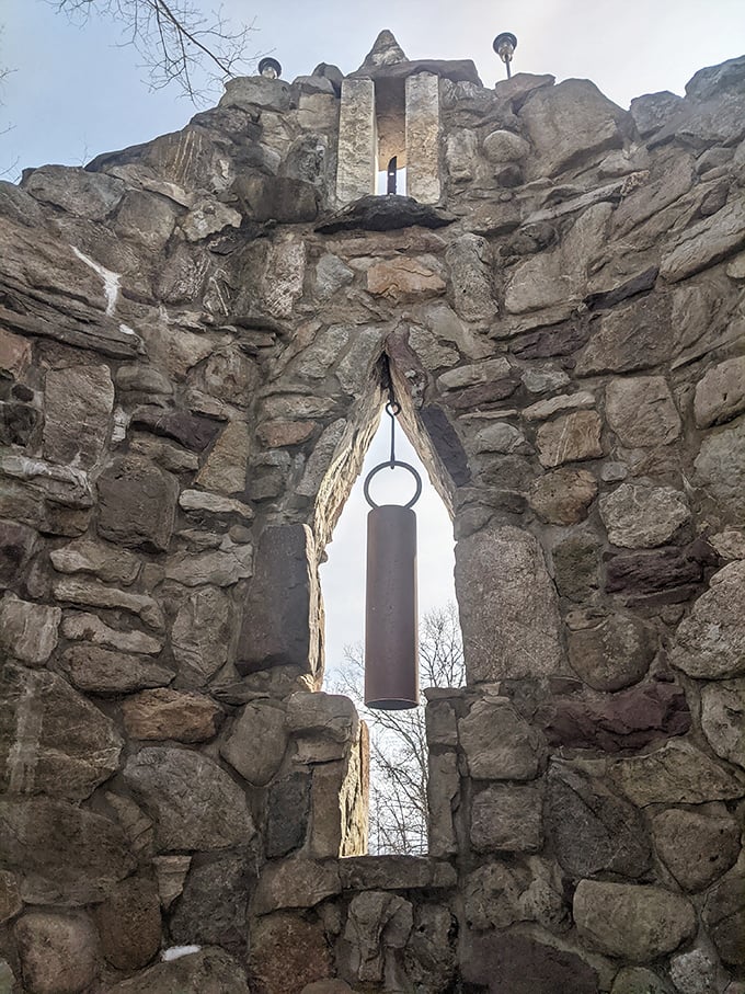 Ancient meets artistry in this bell tower opening. The suspended chime waits patiently for visitors brave enough to send its resonance across the sacred grounds.