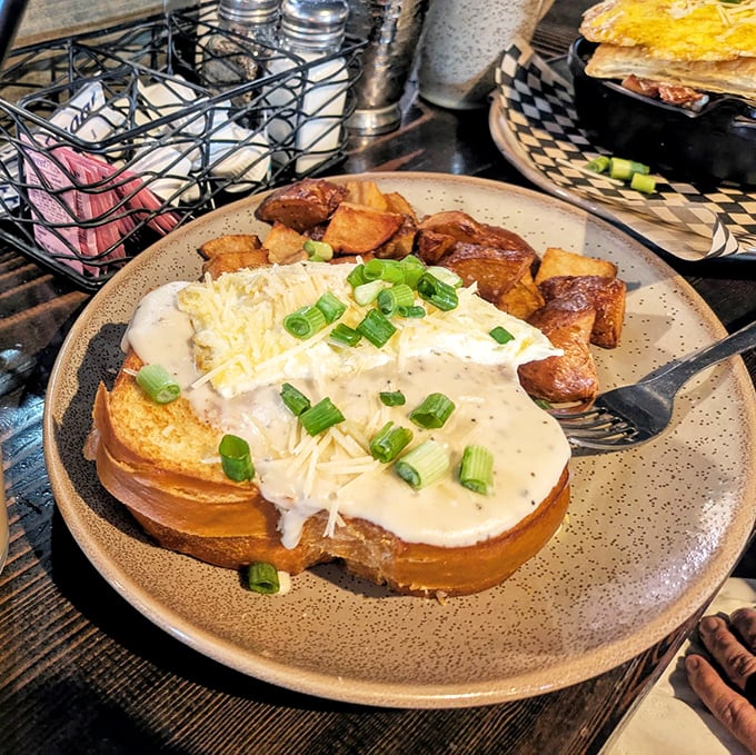 Biscuits and gravy elevated to an art form. That creamy sauce cascading over golden toast could make a grown adult weep with joy.